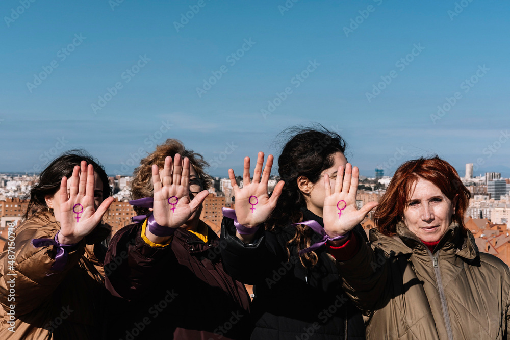 Four women of different ages show the palm of their hands with the ...