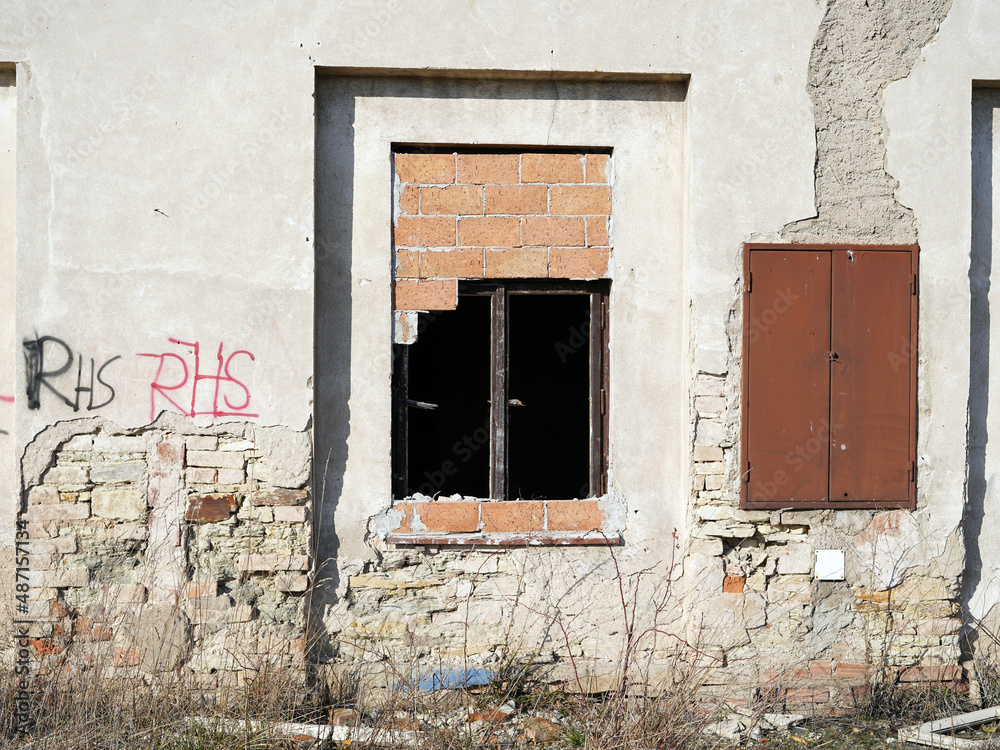 Wall of an old and abandoned building. We see a fallen plaster and a ...