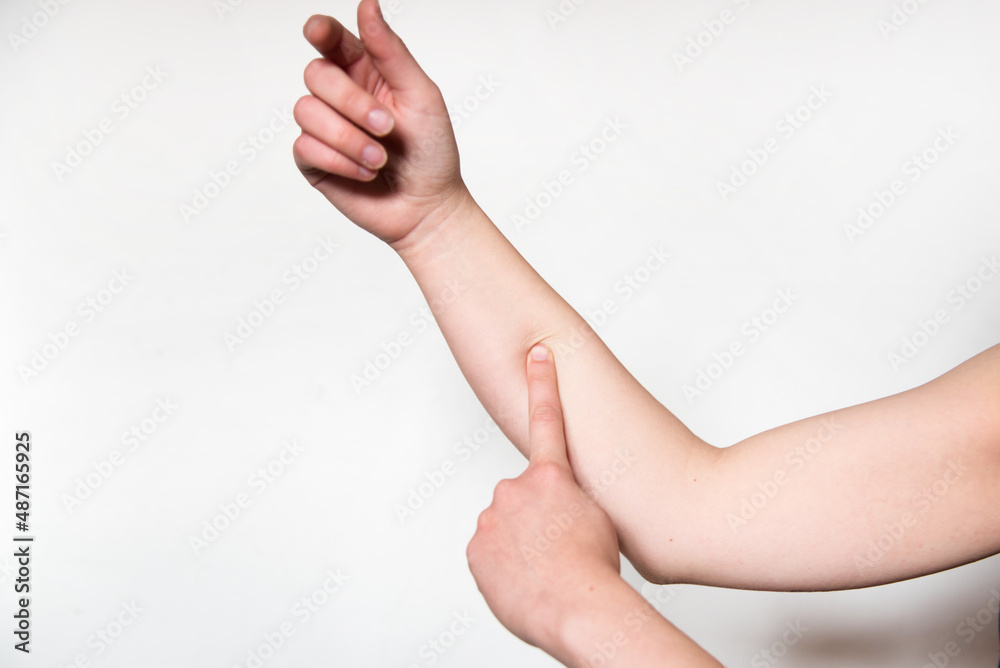Detalle de una mujer ejerciendo presión con un dedo sobre su antebrazo ...
