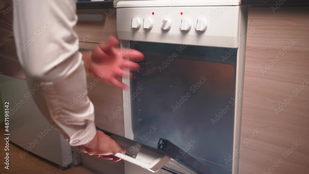 Man Opens an Oven Full of Smoke in the Kitchen. Male Bachelor Ruined ...