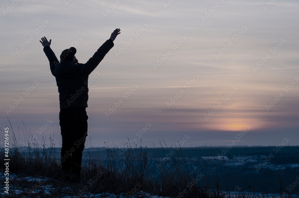Pray. Repentance. Silhouetted men on a background of blue sky and ...