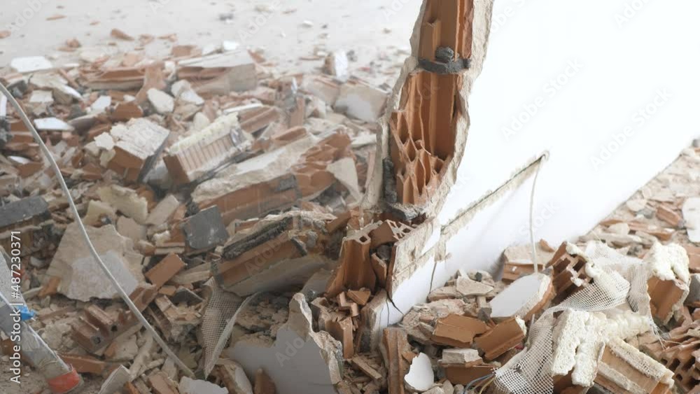 Parts of bricks falling on the ground while a wall is being demolished ...
