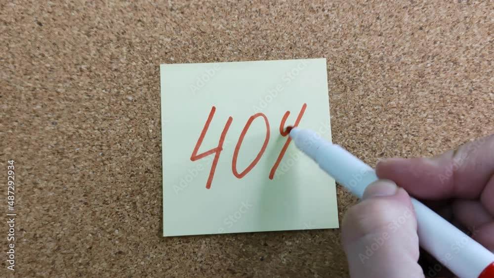 The phrase 40% on a yellow paper sticker. Female hand drawing with a ...