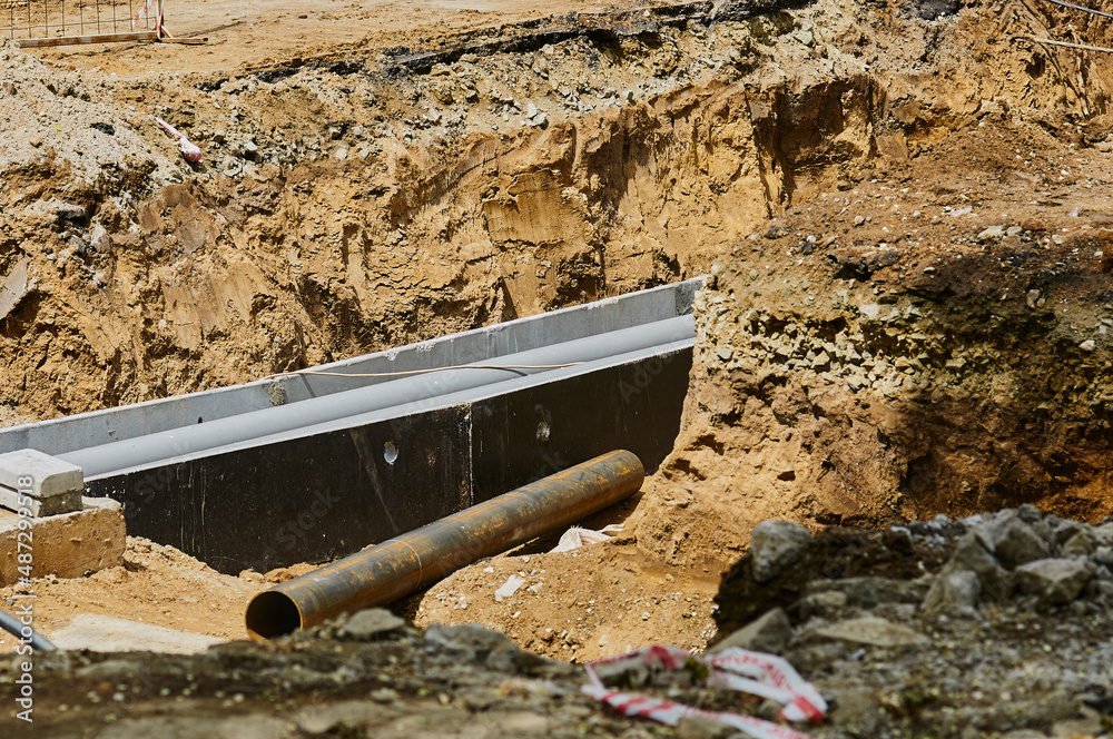 Pit on the street. Laying or replacing underground storm sewer pipes ...