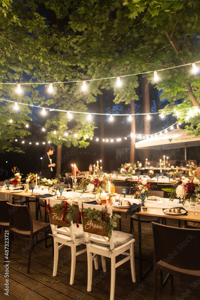 night wedding ceremony, the arch is decorated with flowers, candles and ...