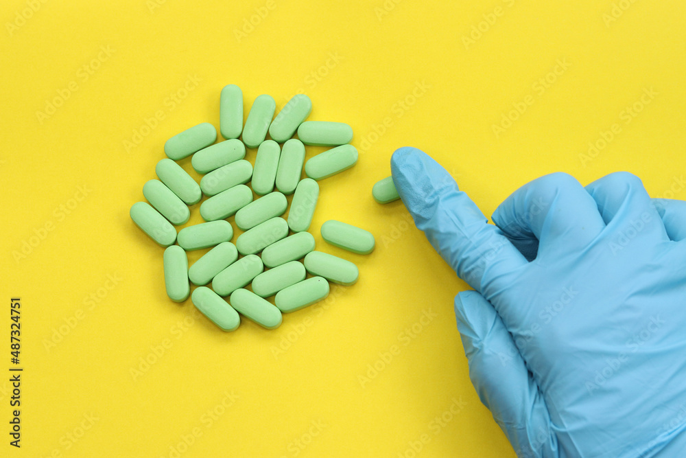 Dose of tablets. A gloved hand counts out tablets Stock Photo | Adobe Stock
