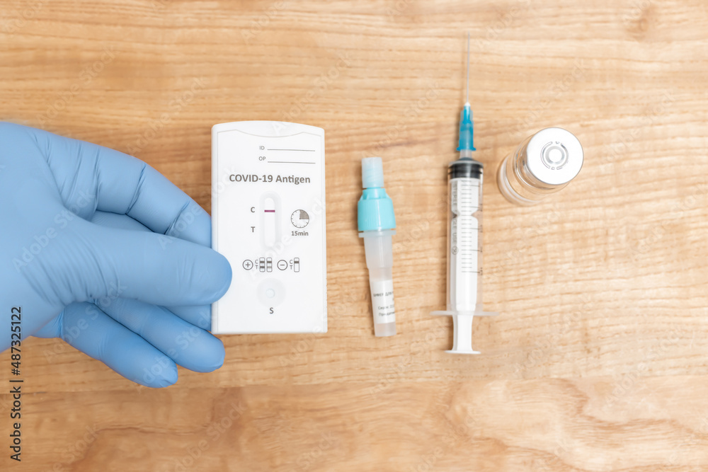 Hand in a medical glove holds rapid antigen test kit for viral disease ...
