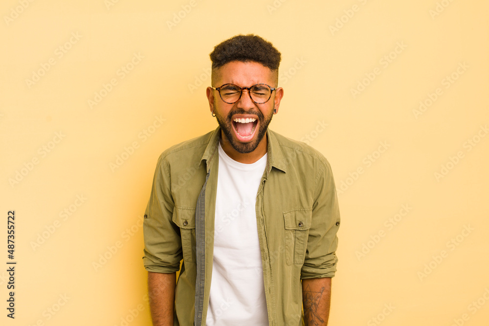 young afro man shouting aggressively, looking very angry, frustrated ...