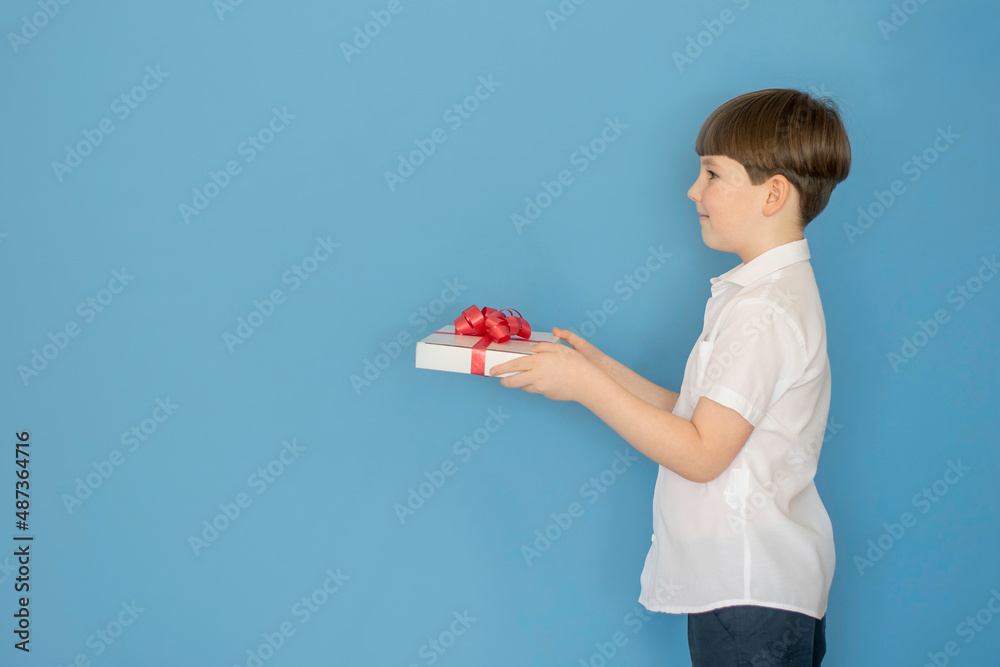 Child boy gives a gift box. Mockup, copy space. Stock Photo | Adobe Stock