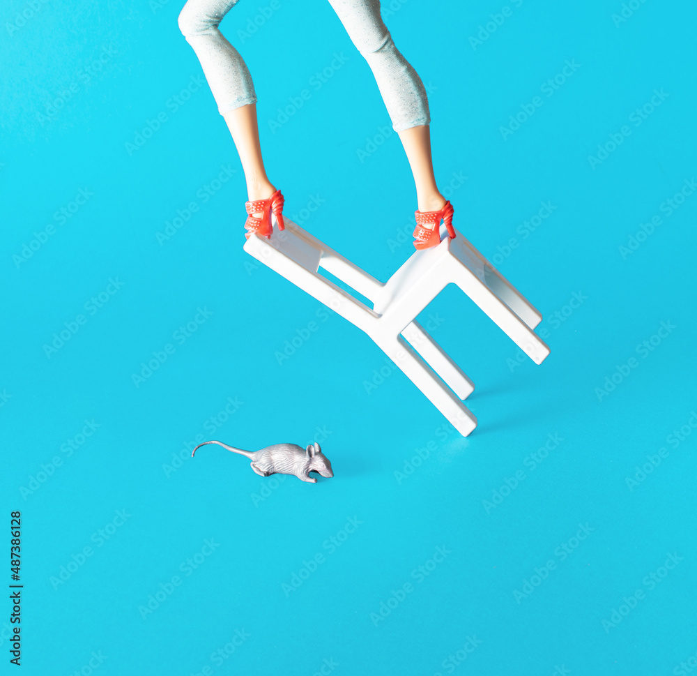 Female legs, chair and mouse. Creative dramatic scene against bright ...