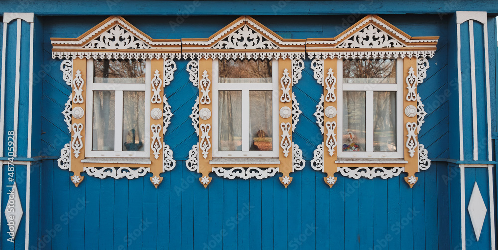 The old window of a rustic Russian wooden house is richly decorated ...
