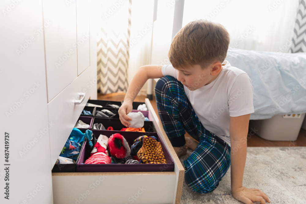Tween boy getting ready for school in the morning, open the wardrobe ...