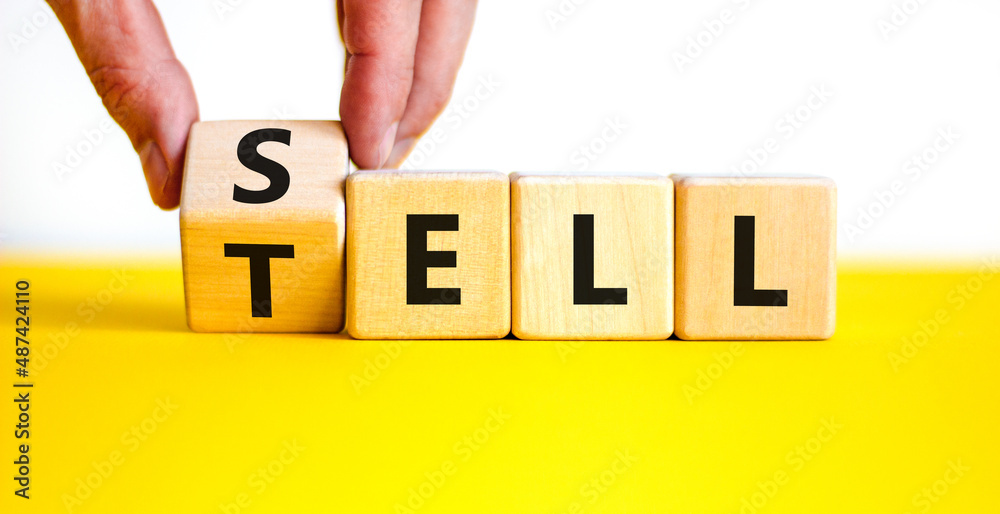 Sell or tell symbol. Businessman turns a wooden cube and changes the ...