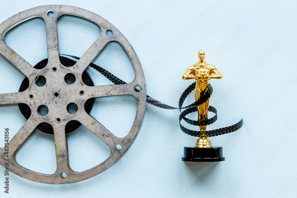 Golden film award statue with reel video tape Stock Photo | Adobe Stock