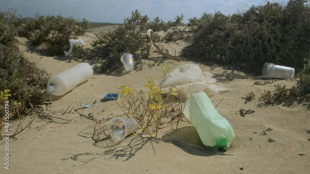 Plastic trash in the desert. Plastic pollution in a sandy desert in ...