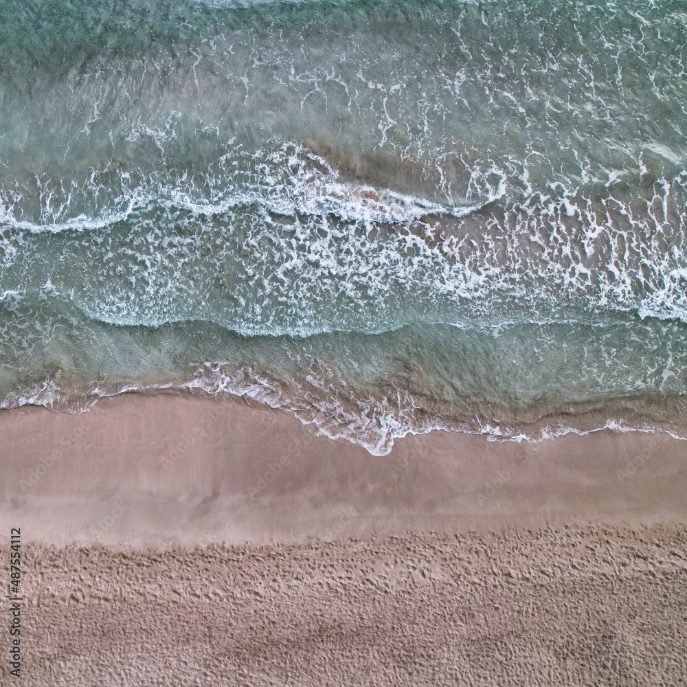 Fotka „Foto aérea de la arena, mar y olas en Cala Llenya (Ibiza) tomada ...