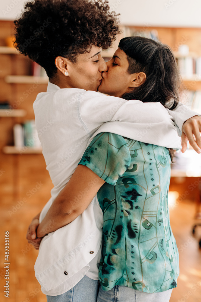 Cute lesbian couple kissing indoors Stock Photo | Adobe Stock