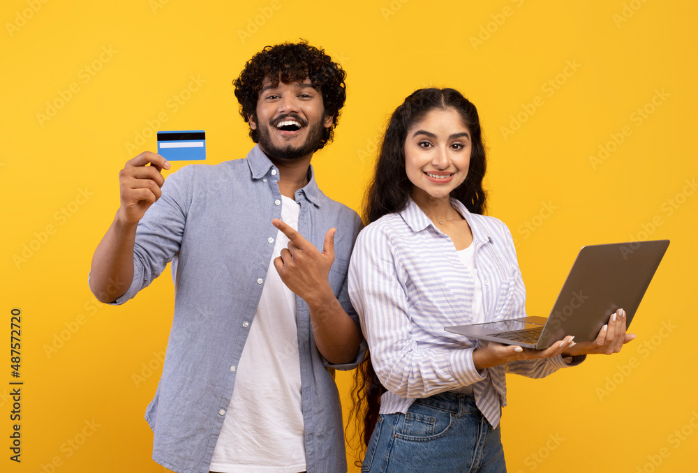 Online banking and e-commerce. Positive indian couple making purchases ...