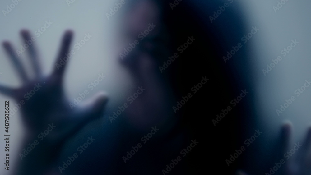 Defocused shot of person trapped in emotional problems behind glass ...