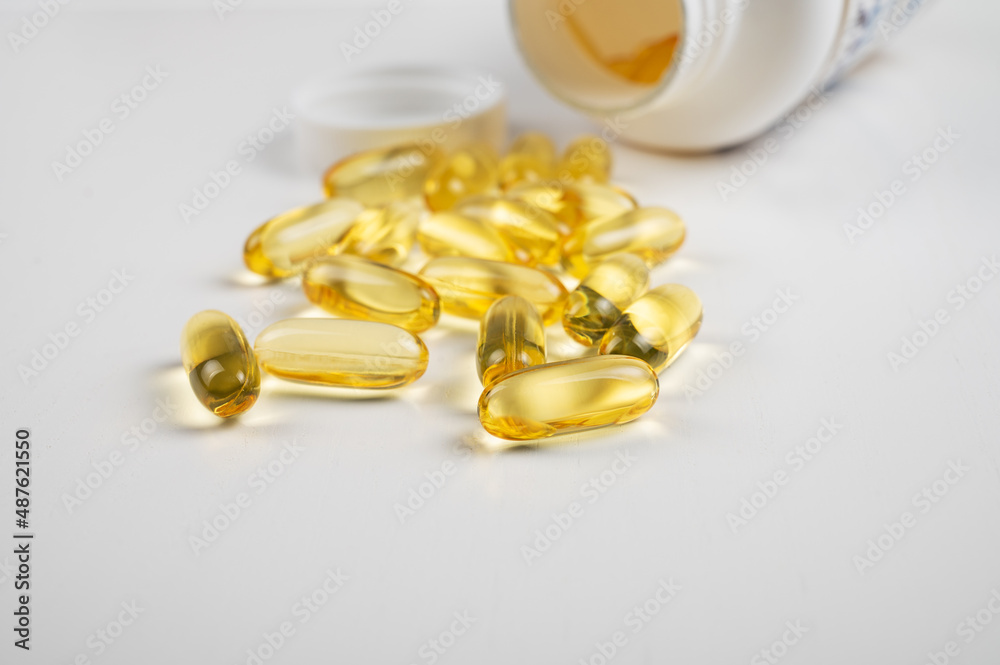 Gold fish oil isolated on white background. Pile of fish oil with Omega ...