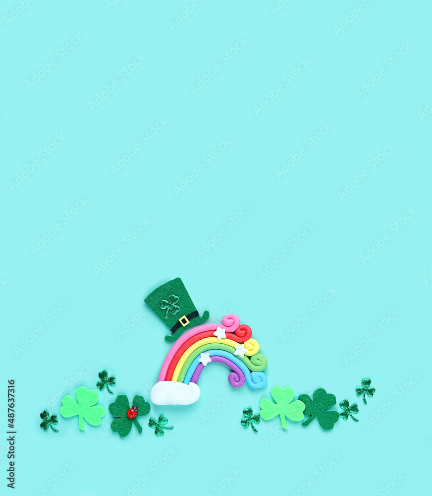 clover leaves, toy rainbow and leprechaun hat on abstract green ...
