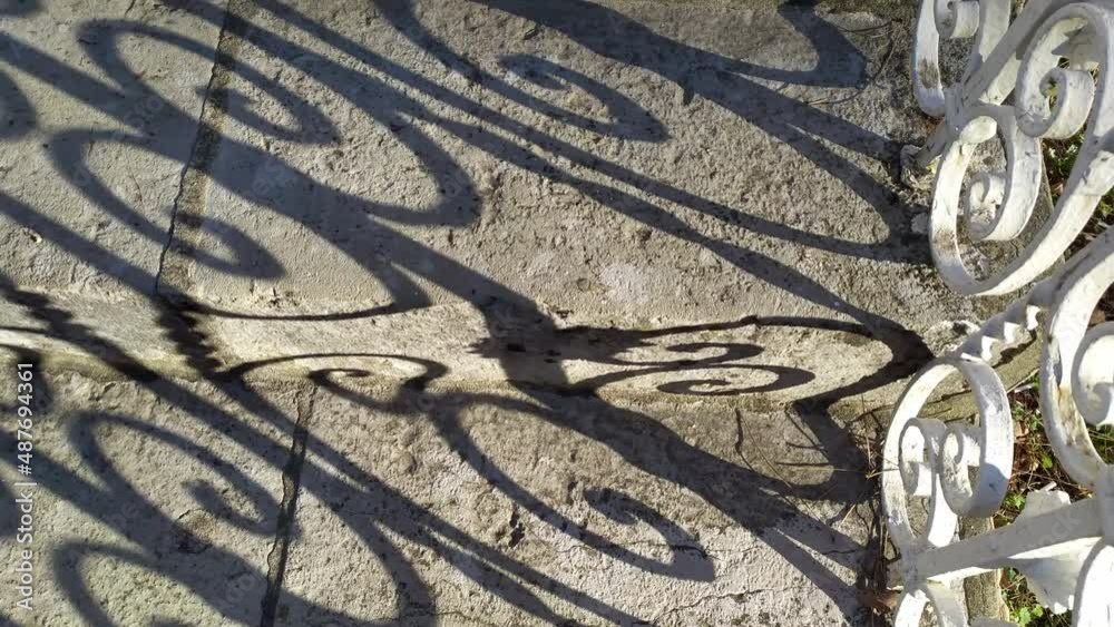 Shadow on stone stairs made of slabs cast by the curved pattern of ...