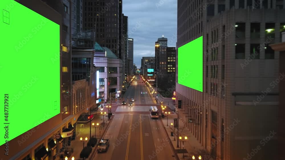 Low over streets with green screens on billboards in a city - Aerial 3D ...