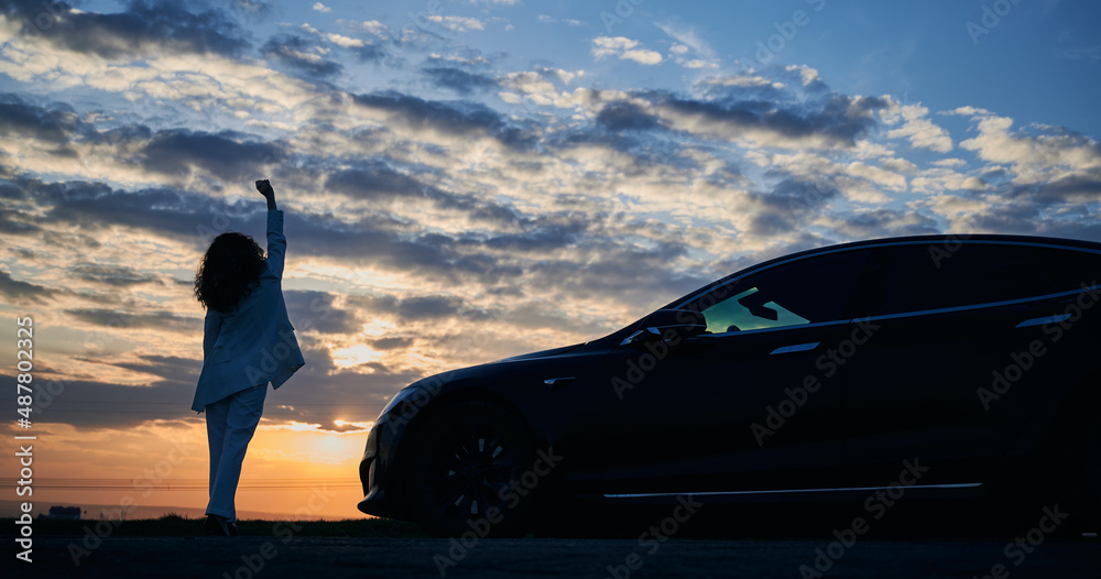 Beautiful sunset. Silhouette of girl standing on road, enjoying ...