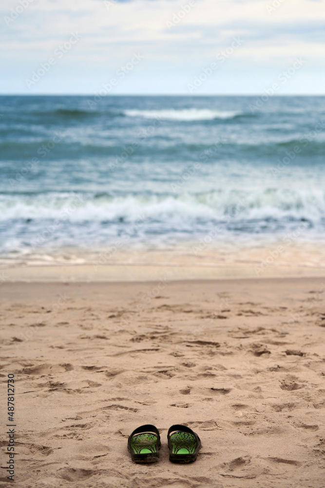 Sandals on sandy beach, beautiful Baltic Sea background, drowning ...