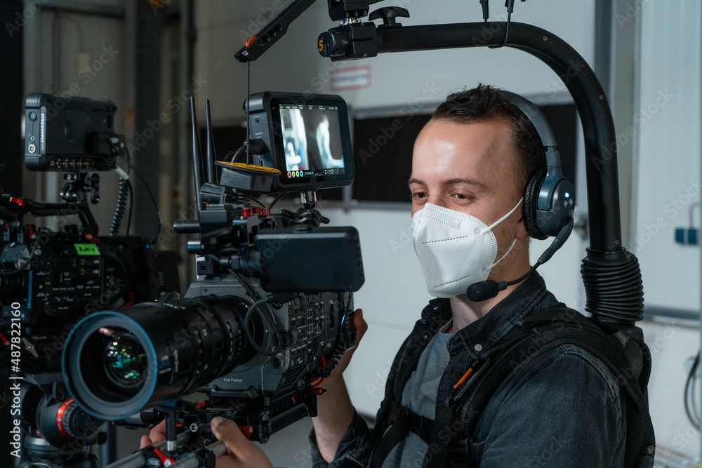 professional tv camera man filming with a cinema camera. during corona ...