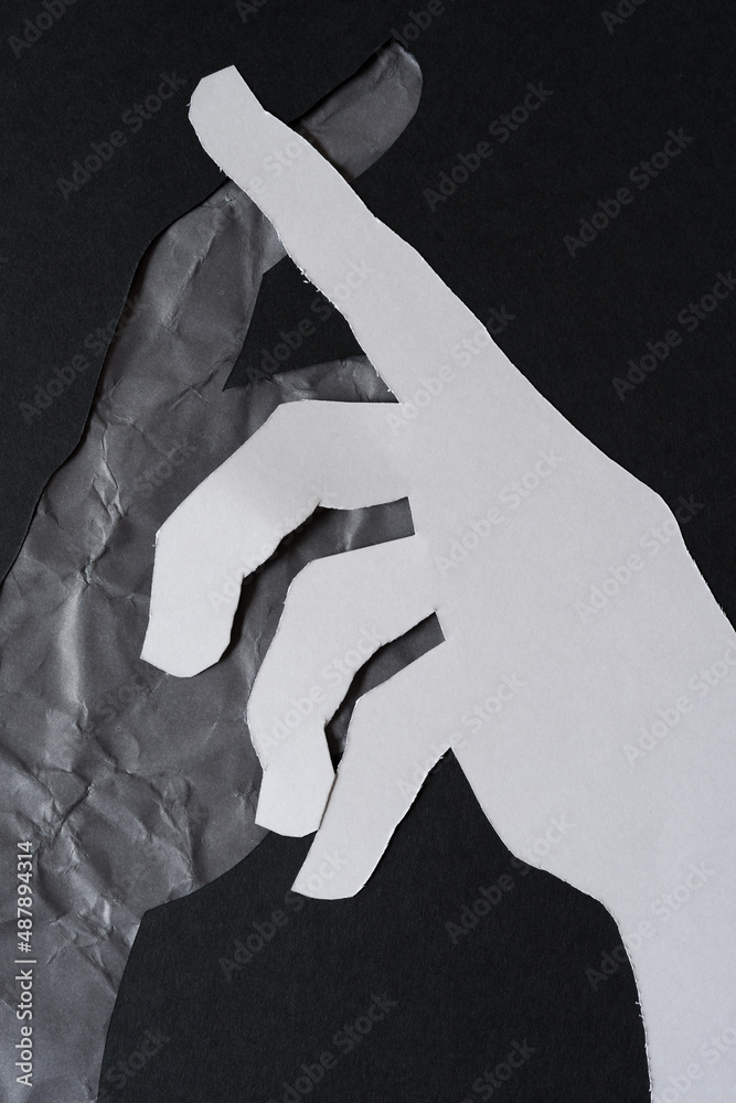 pointing finger and hand on cutout of a pointing finger with crumpled ...