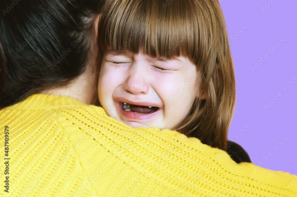 A loving sister hugging a sad, crying child. A little girl is crying on ...