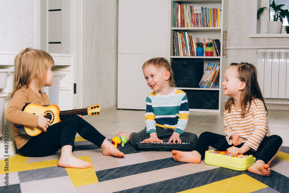 Smiling children playing musical instruments at home. Brother and ...