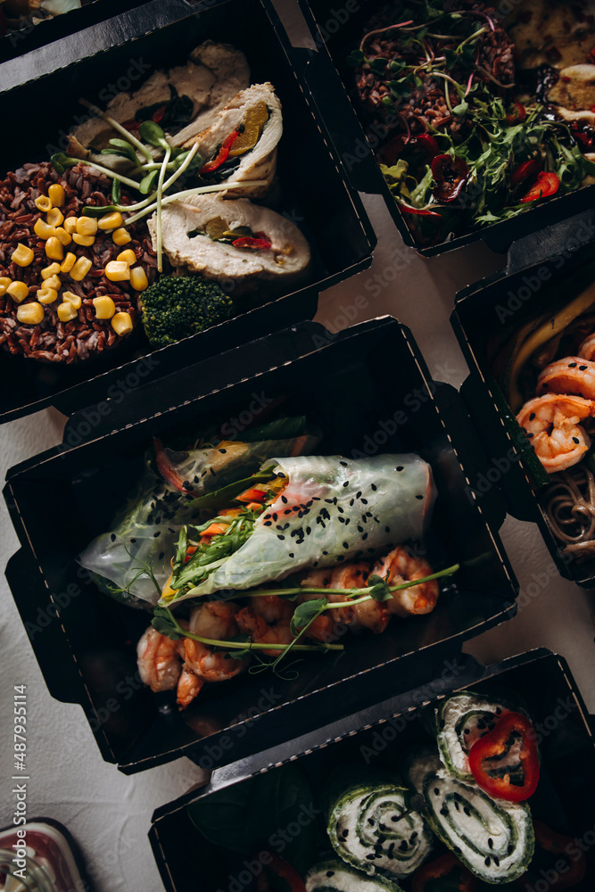 different portions of a healthy diet in paper bowls. spring rolls and ...