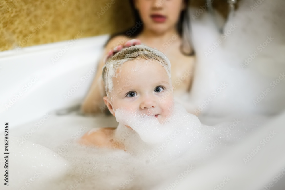 Cute sibling children bathe in a bubble bath together. Children in the ...