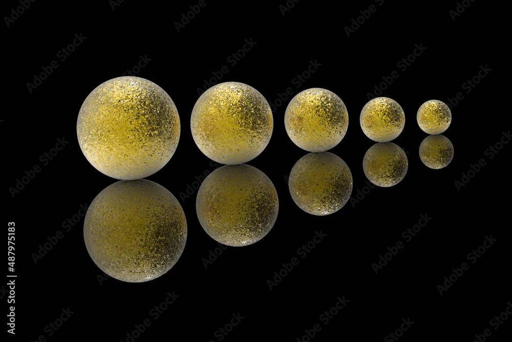 Five metal balls of different sizes of gold color on black background ...