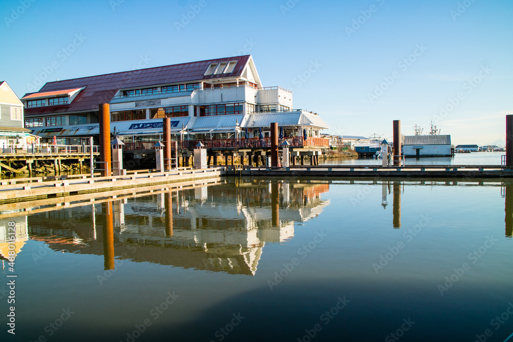 Pier, porto ou atracadouro de barcos de pesca e veleiros, com casas e ...