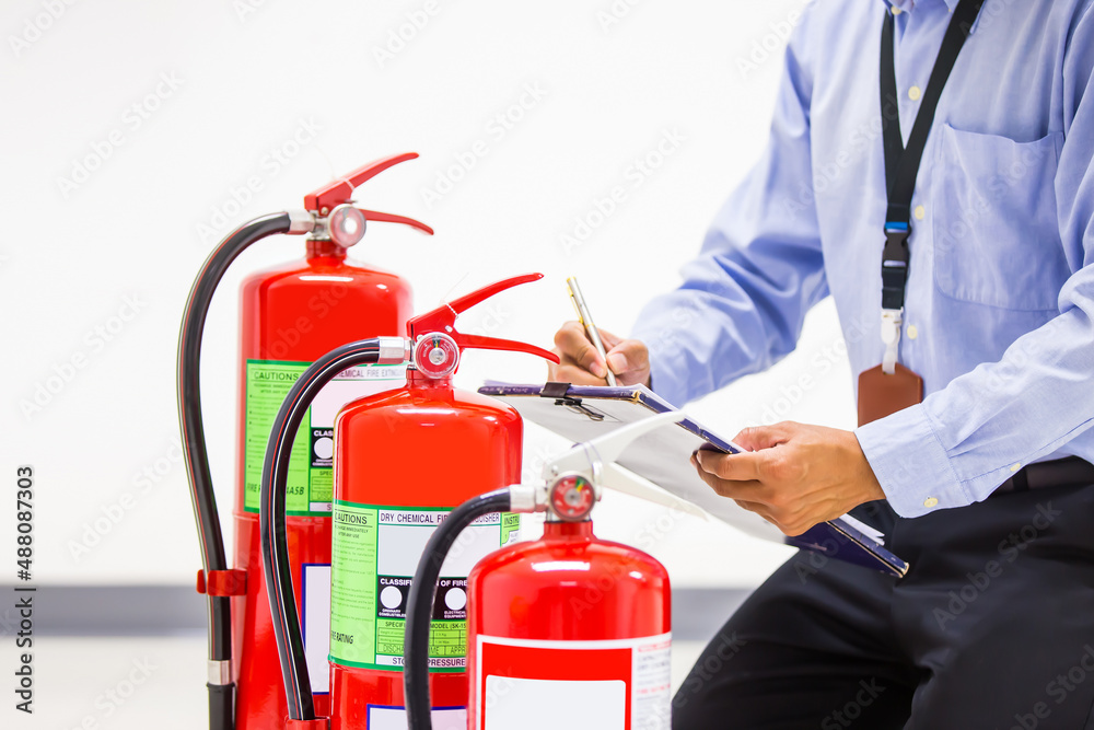 Fire extinguisher has hand engineer inspection checking pressure gauges ...