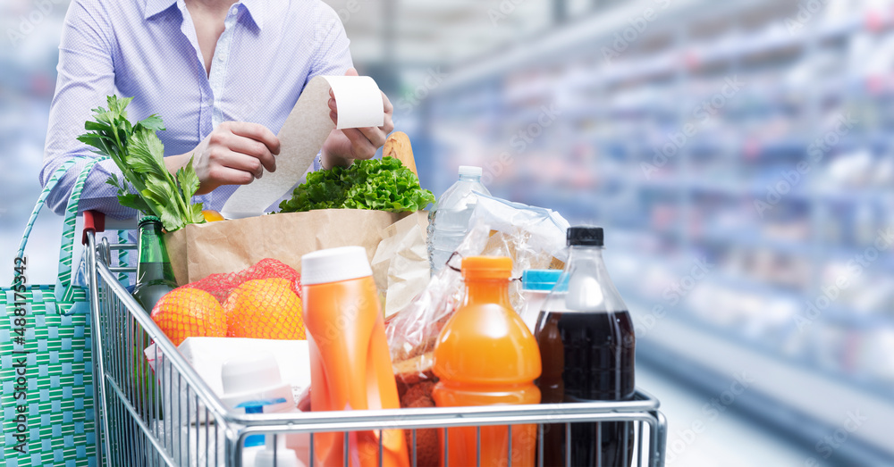 Woman checking a grocery receipt at the supermarket Stock Photo | Adobe ...