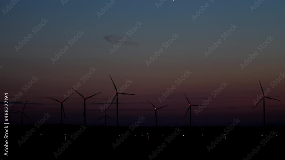 Wind farm at night. Silhouettes of powerful turbines with large ...