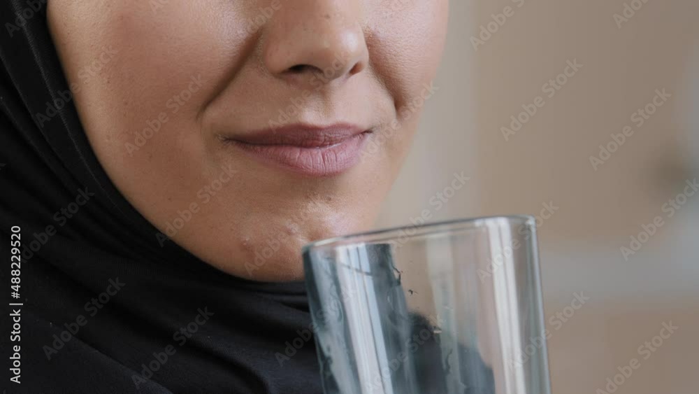 Happy muslim young girl in hijab drinking pure mineral water hydrating thirst enjoy refreshing ...