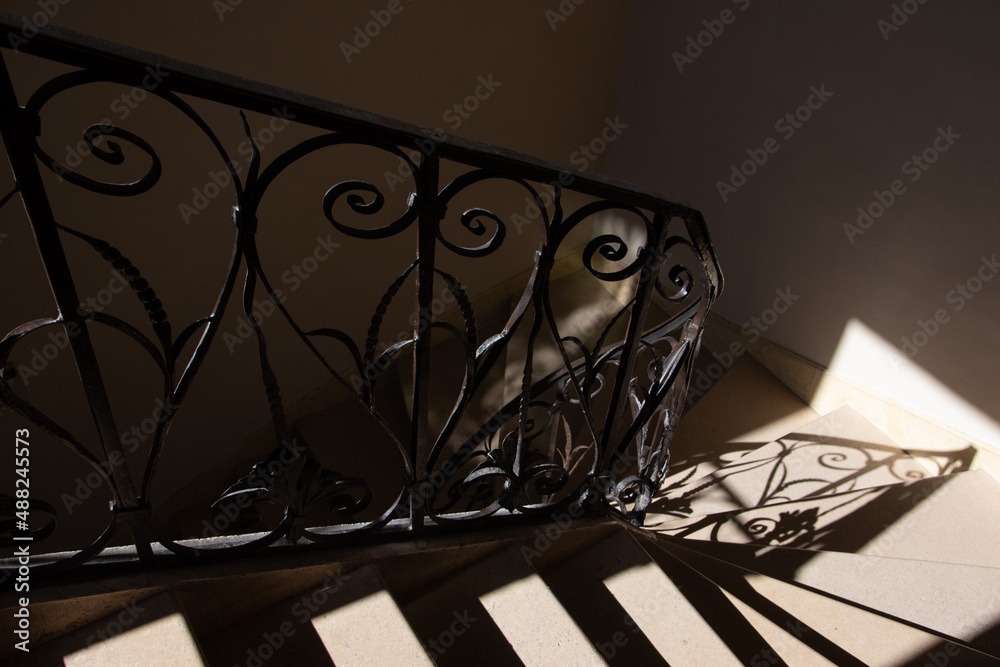 Ornate antique forging railing in sunlight rays coming from window at ...