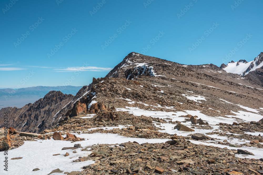 Scenic landscape with mountain peak and old rocks among snow in ...