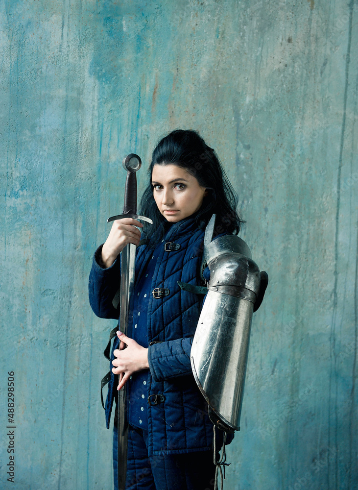 Beautiful brunette woman in ancient iron knightly armor. Medieval ...