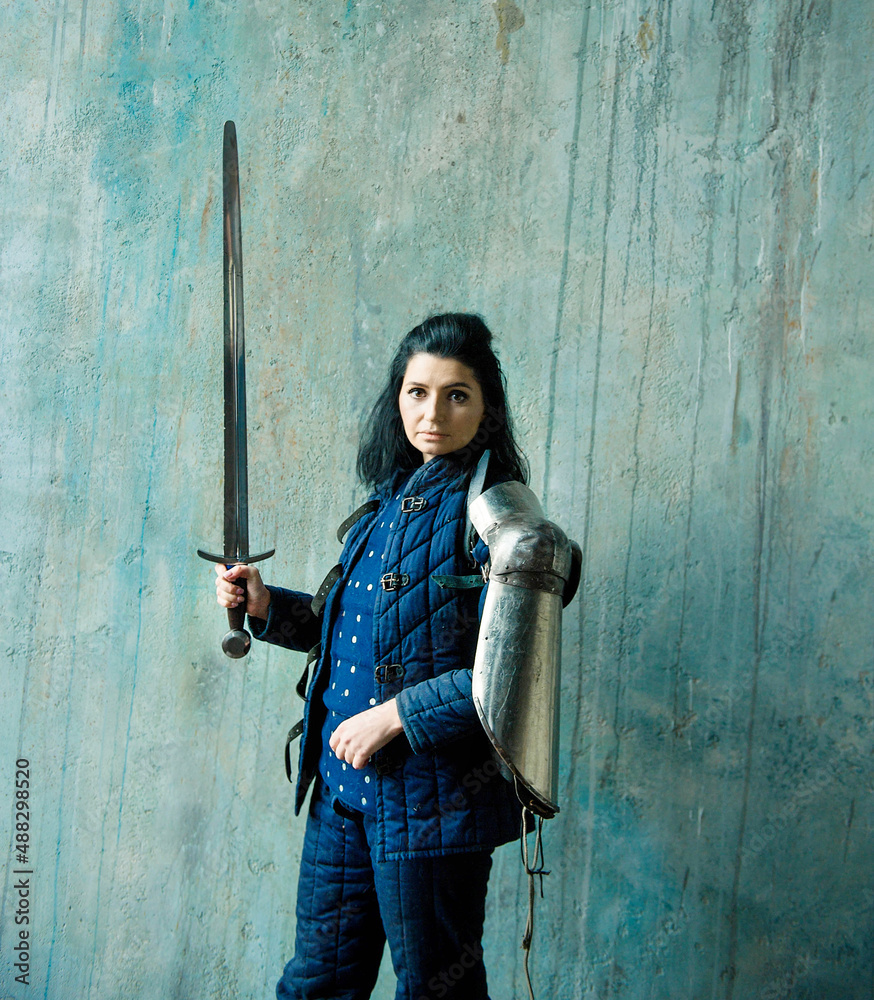 Beautiful brunette woman in ancient iron knightly armor. Medieval ...