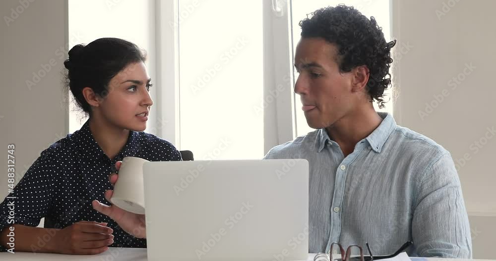 Vidéo Stock Two multiracial colleagues talking sit at desk in office ...