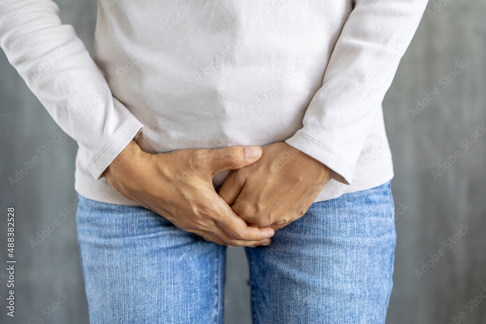 Woman covering her crotch with her hand, urinary incontinence, stomach ...