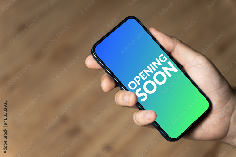 Opening soon - hand holding a phone Stock Photo | Adobe Stock