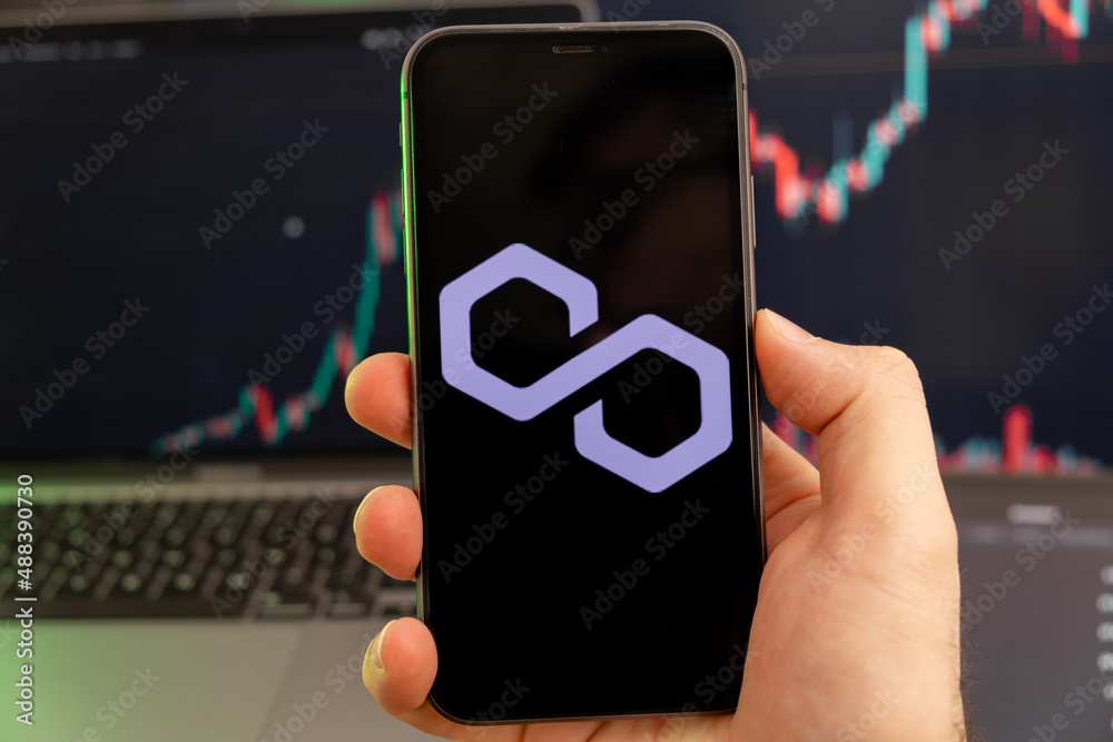 Polygon MATIC cryptocurrency logo on the screen of a smartphone in mans ...