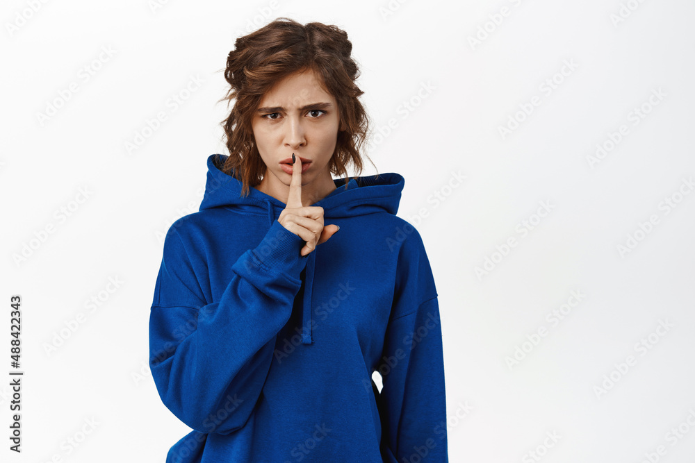 Angry bossy girl shushing, press finger at lips and hush, shh be quiet ...